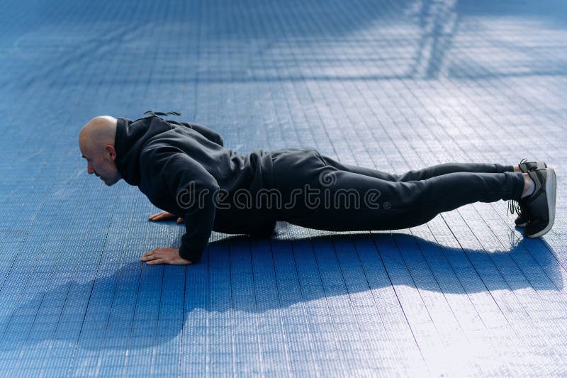 Engaged in a Brisk Workout: Push-Up Session on Blue Floor Stock Image ...