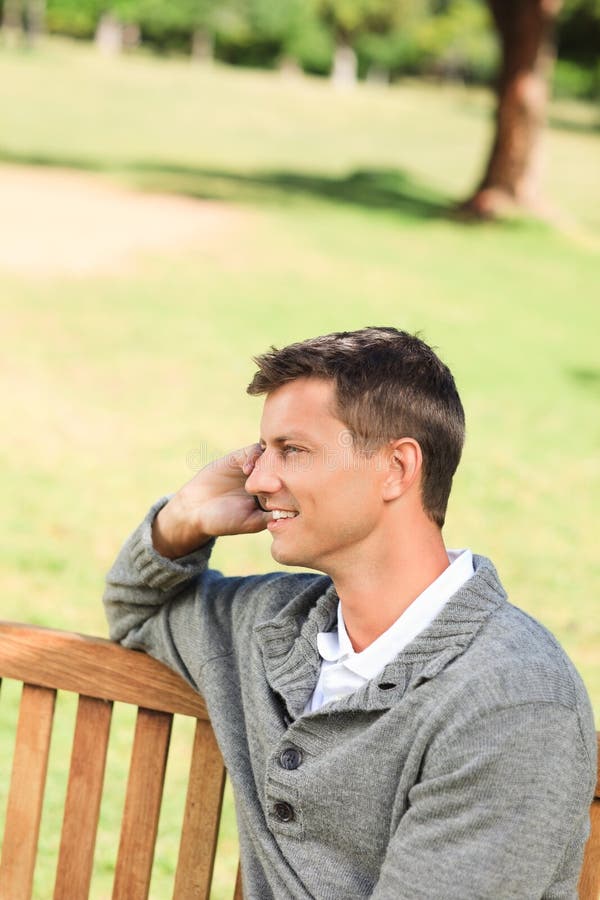 Man phoning on the bench stock photo. Image of outdoor - 18741550