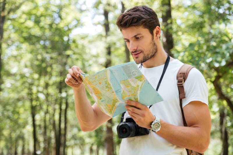 Man with Photo Camera Standing and Using Map in Forest Stock Image ...