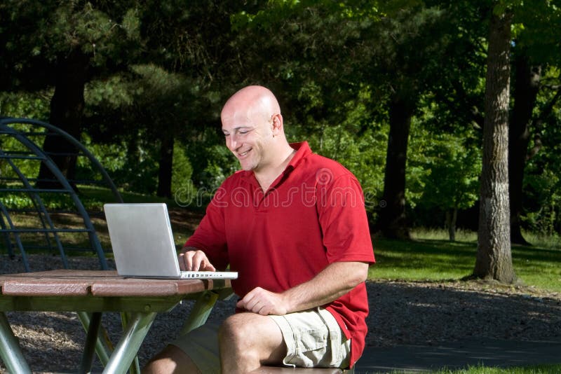 Man at Picnic Table on Computer - Horizontal Stock Photo - Image of ...