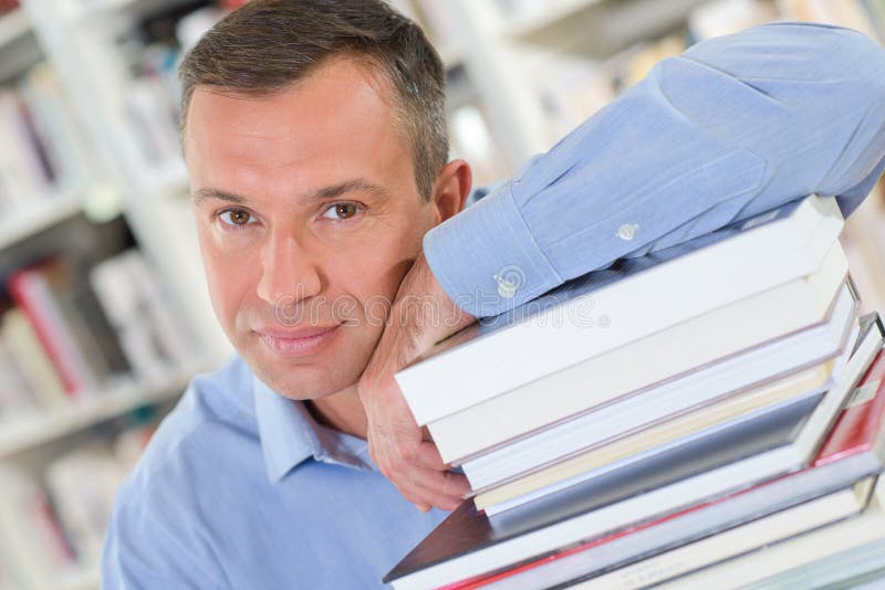 Man with pile books stock photo. Image of bookshop, library - 262851948