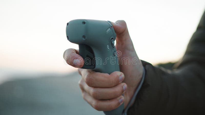 Man Pilot a Drone with Remote Single Hand Controller on the Beach Near ...