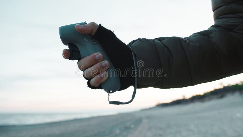 Man Pilot a Drone with Remote Single Hand Controller on the Beach Near ...