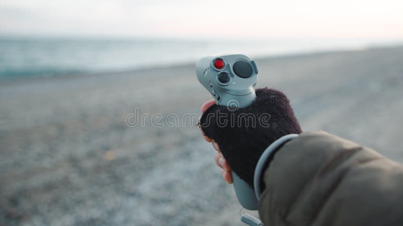 Man Pilot a Drone with Remote Single Hand Controller on the Beach Near ...