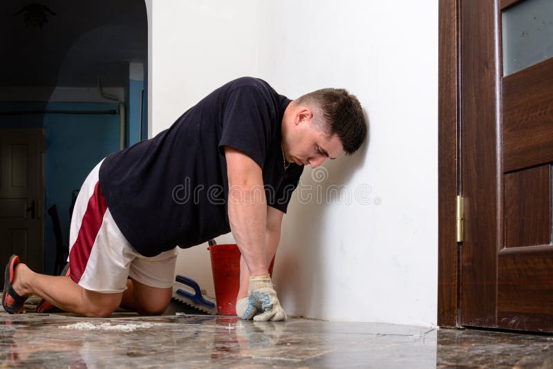 Man Placing Ceramic Floor Tile in Position Over Adhesive Stock Photo ...