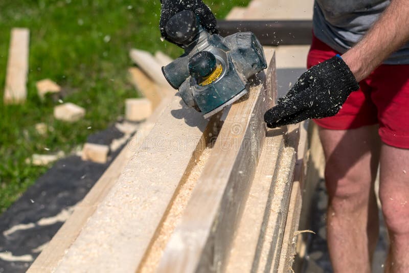 Man Planing Boards with Electric Tools, Chips Flying in All Directions ...