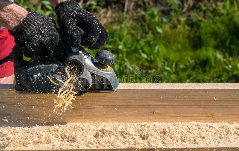Man Planing Boards with Electric Tools, Chips Flying in All Directions ...