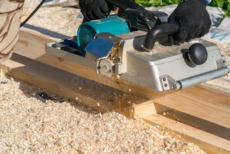 Man Planing Boards with Electric Tools, Chips Flying in All Directions ...