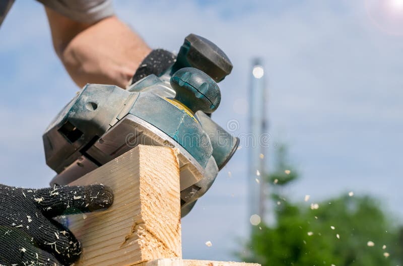 Man Planing Boards with Electric Tools, Chips Flying in All Directions ...