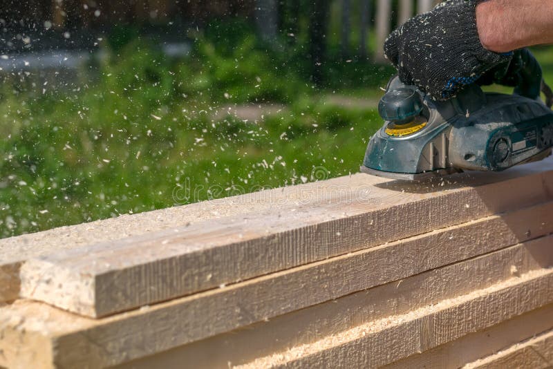 Man Planing Boards with Electric Tools, Chips Flying in All Directions ...