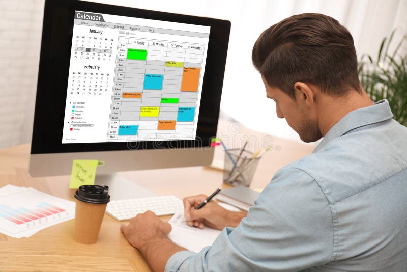 Handsome Man Planning His Schedule with Calendar App on Computer Stock ...