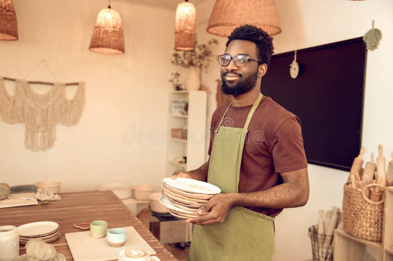 Man in Apron Standing with Ceramic Plates in Hands Stock Photo - Image ...