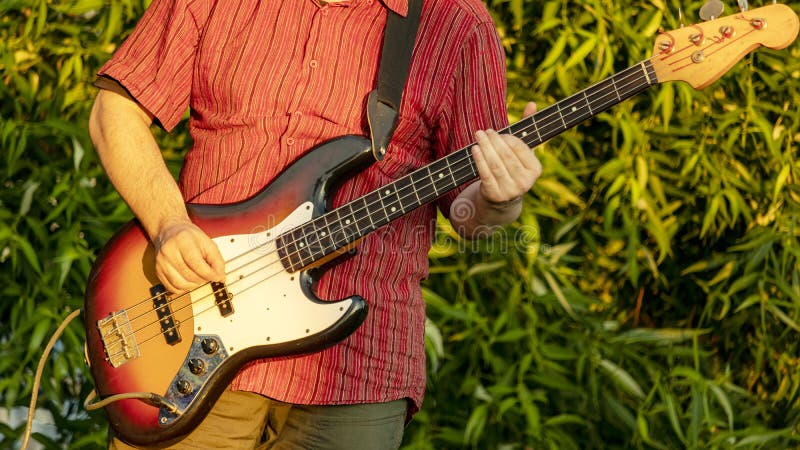 A Man Playing Bass Guitar in a Park Stock Image - Image of music ...