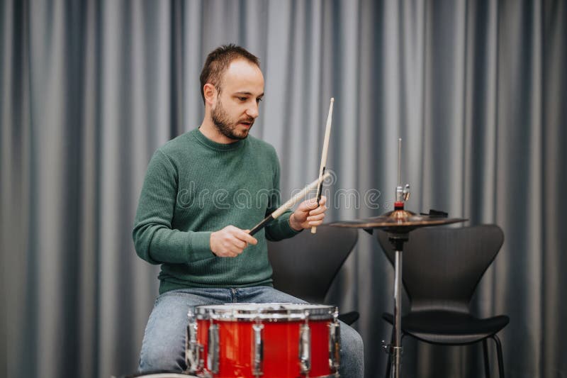 Man Playing Drums in a Music Studio with Focused Expression Stock Photo ...
