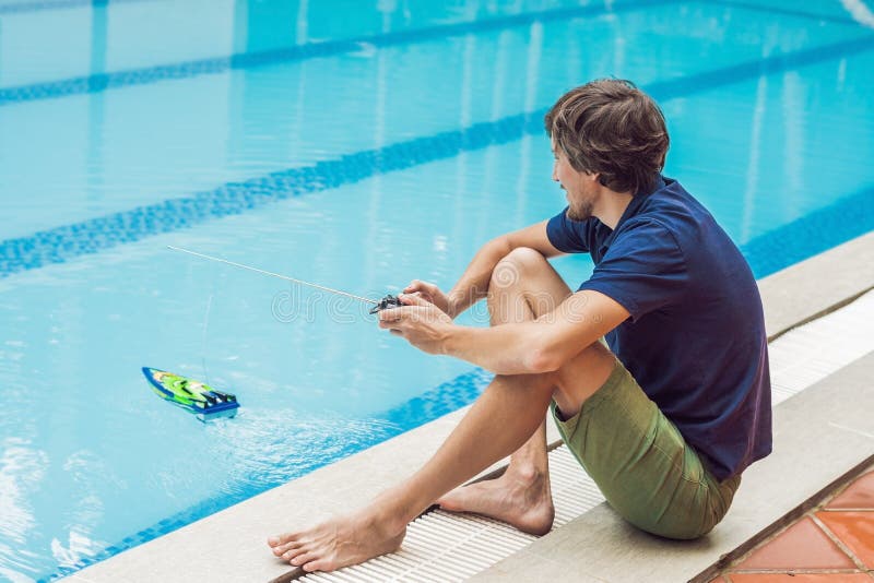 Man Playing with a Remote Controlled Boat in the Pool Stock Photo ...