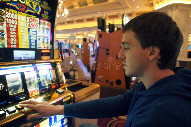 Man playing slot machine stock image. Image of playing - 97756549