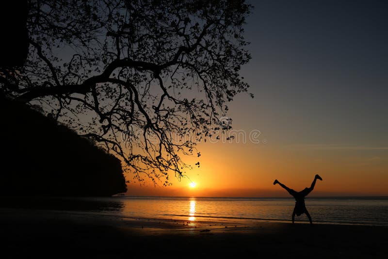 Man Playing Somersaults on the Beach at Sunset, Red Sky Stock Image ...