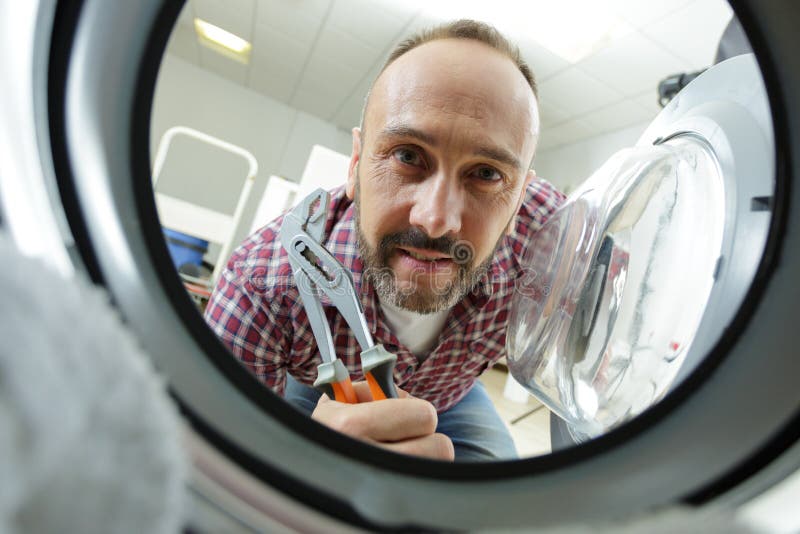 Man with Pliers Looking into Washing Machine Drum Stock Image - Image ...