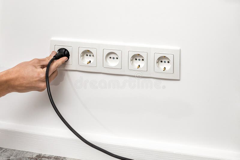 Man Plugging Cord into a Electrical Outlet Stock Photo - Image of cord ...
