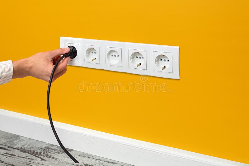 Man Plugging Cord into a Electrical Outlet Stock Photo - Image of ...