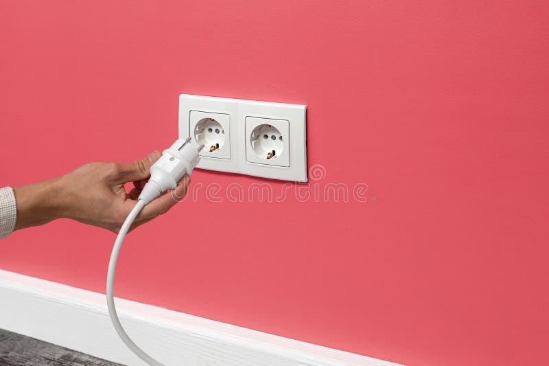 Man Plugging Cord into a Electrical Outlet Stock Image - Image of ...