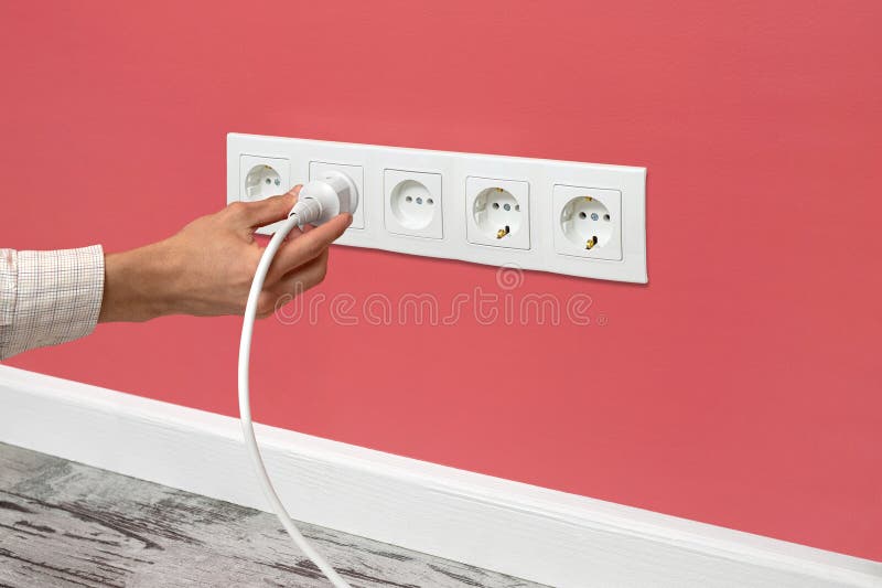 Man Plugging Cord into a Electrical Outlet Stock Image - Image of ...