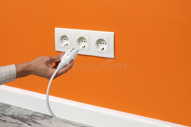Man Plugging Cord into a Electrical Outlet Stock Image - Image of empty ...