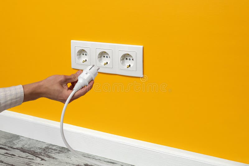 Man Plugging Cord into a Electrical Outlet Stock Image - Image of ...