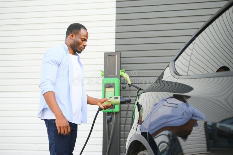 Man Plugging in Electric Car Outside Office in Car Park Charging Stock ...