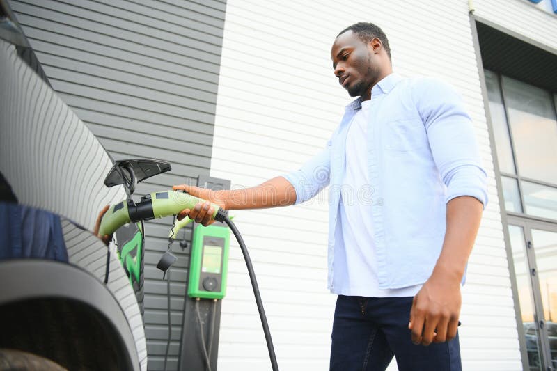 Man Plugging in Electric Car Outside Office in Car Park Charging Stock ...