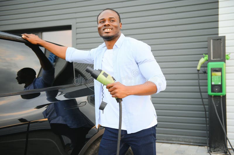 Man Plugging in Electric Car Outside Office in Car Park Charging Stock ...