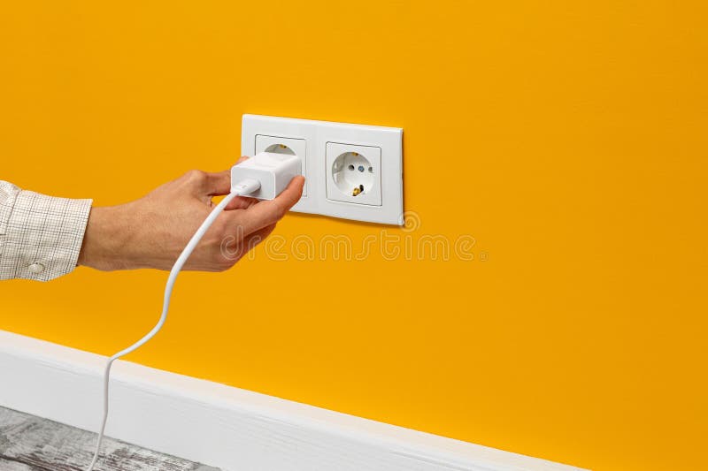 Man Plugging Phone Adapter into a Electrical Outlet Stock Photo - Image ...