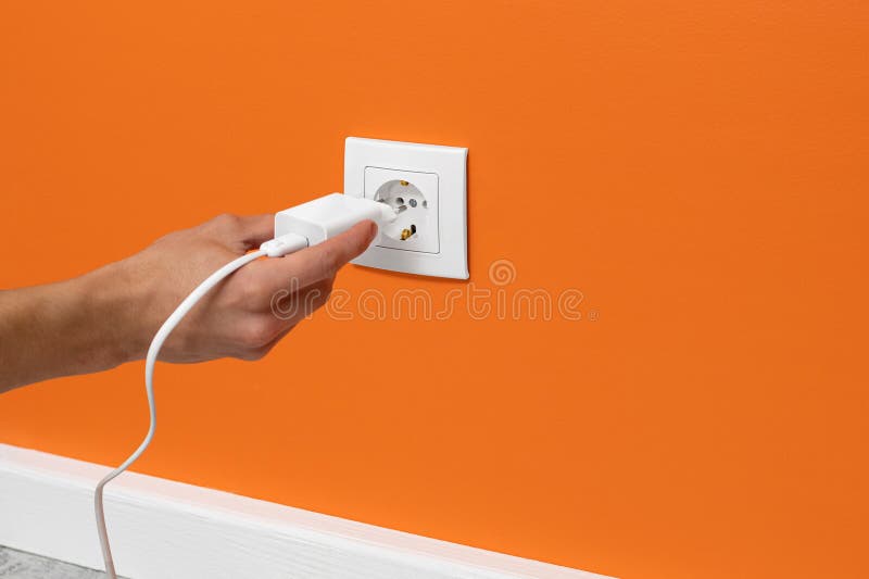 Man Plugging Phone Adapter into a Electrical Outlet Stock Image - Image ...