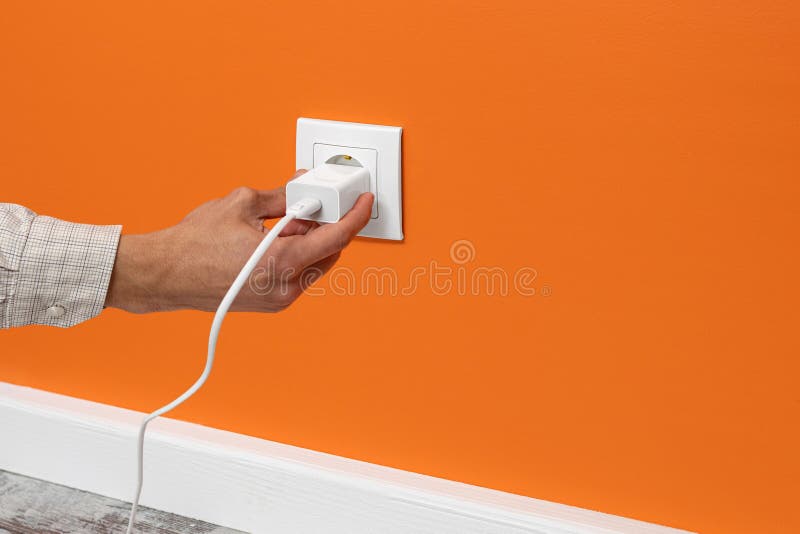 Man Plugging Phone Adapter into a Electrical Outlet Stock Photo - Image ...