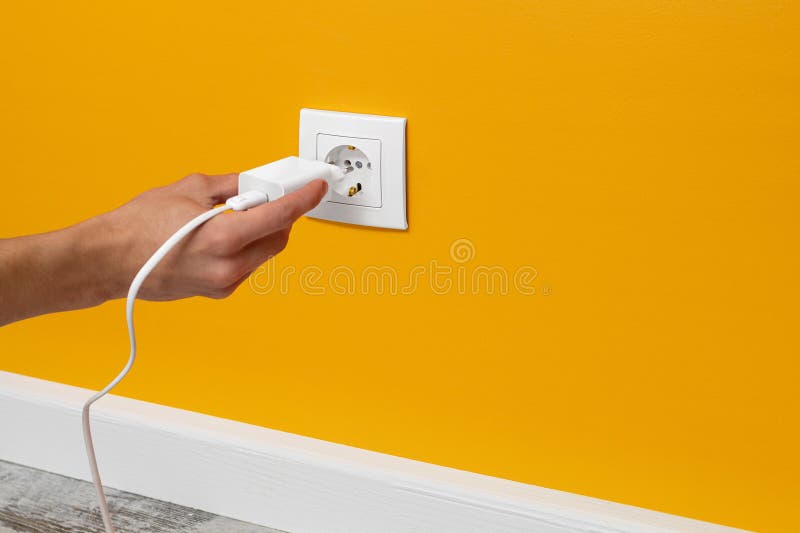 Man Plugging Phone Adapter into a Electrical Outlet Stock Photo - Image ...