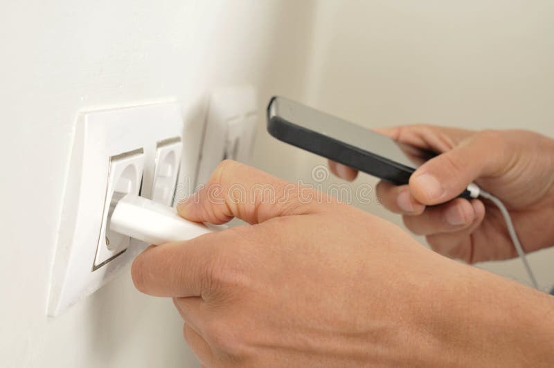 Man Plugging in the Plug of His Smpartphone in a Socket Stock Image ...
