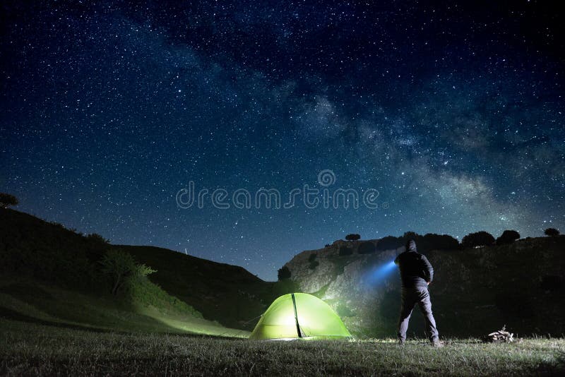Man Pointing Blue Flashlight To Mountain Below Starry Sky in Nebrodi ...