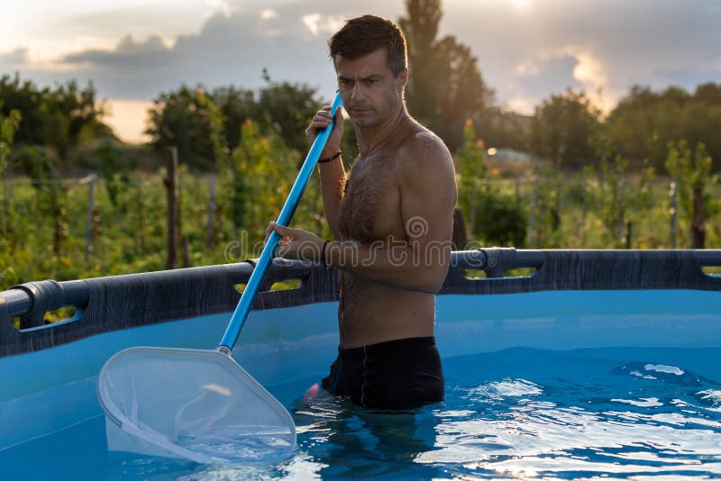 Man cleaning pool with net stock image. Image of cleaning - 256069611