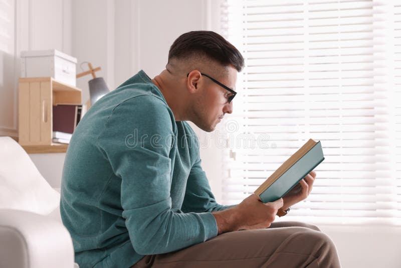 Man with Poor Posture Reading Book at Home Stock Photo - Image of ...