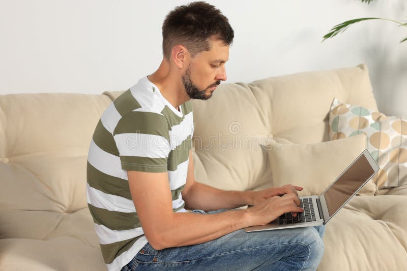 Man with Poor Posture Using Laptop on Sofa at Home Stock Photo - Image ...