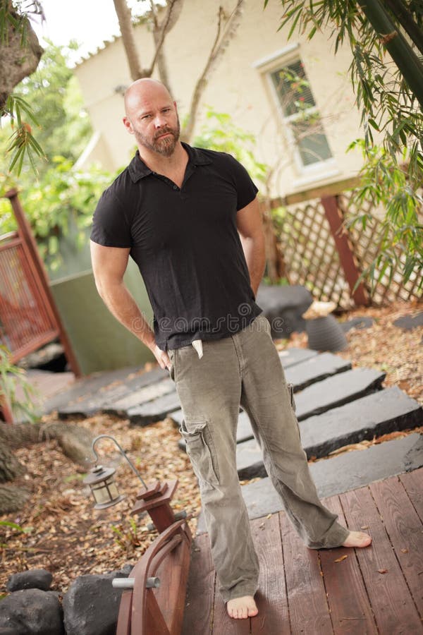 Man Posing Barefoot in the Garden Stock Photo - Image of bald, person ...