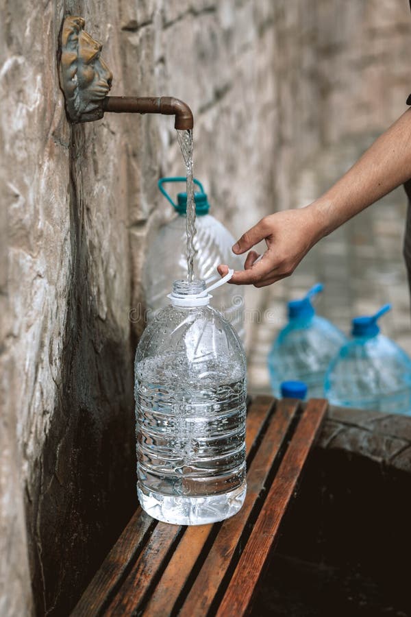 Man Pour Fresh Spring Water into Plastic Bottle from a Natural Source ...