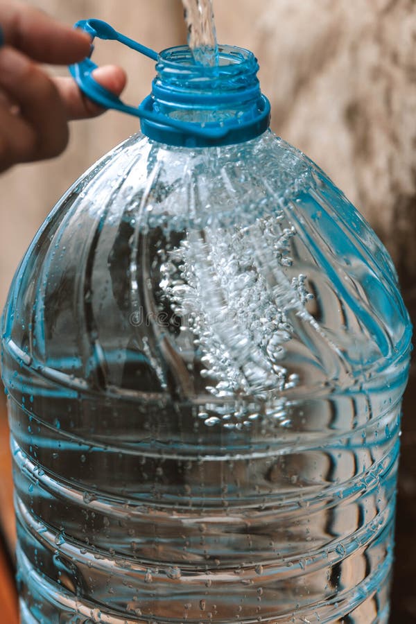 Man Pour Fresh Spring Water into Plastic Bottle from a Natural Source ...