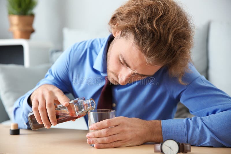 Man Pouring Alcohol from Bottle into Glass at Table. Alcoholism Concept ...
