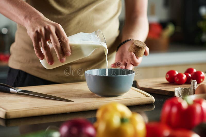 Man Pouring Milk into Bowl stock photo. Image of lifestyle - 298830882