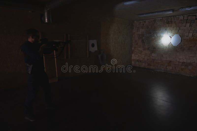 A Man Practices Tactical Shooting with a Rifle with a Weapon Flashlight ...