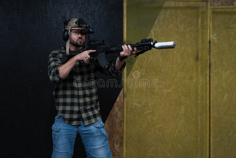 A Man Practices Tactical Shooting Using a Night Vision Device and a ...