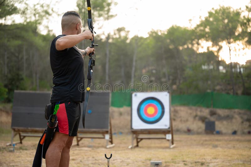 A Man is Practicing Archery in a Field Stock Image - Image of black ...