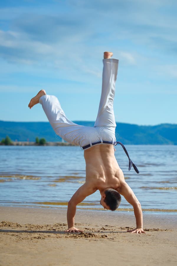 Man Practicing Capoeira on the Beach. the Man Does the Fighting Element ...