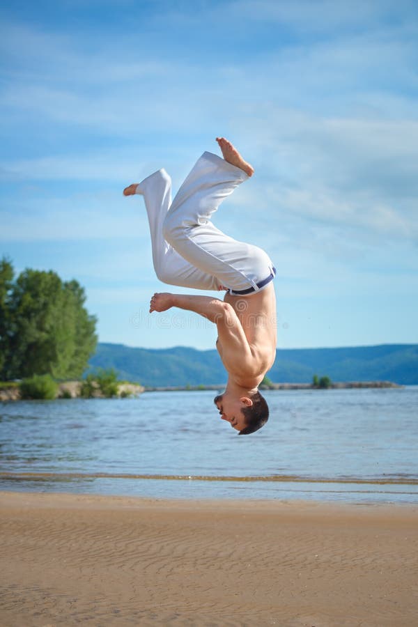 Man Practicing Capoeira on the Beach. the Man Does the Fighting Element ...